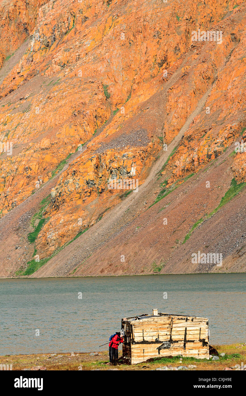Woman inspects hunting cabin near the shore of Etah, an old Inuit ...