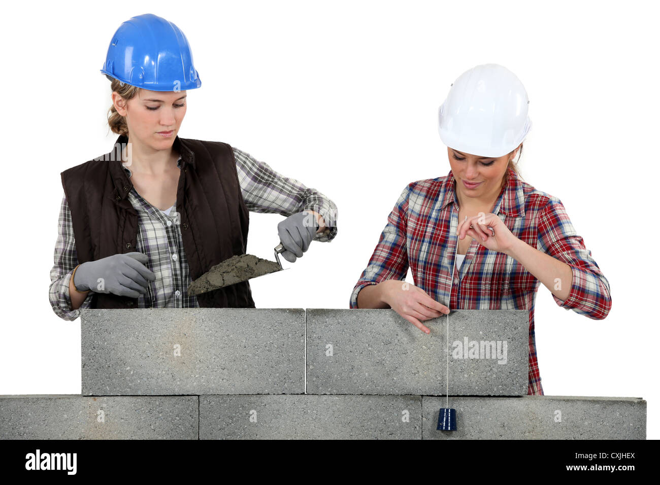Two female mason working on a wall Stock Photo - Alamy