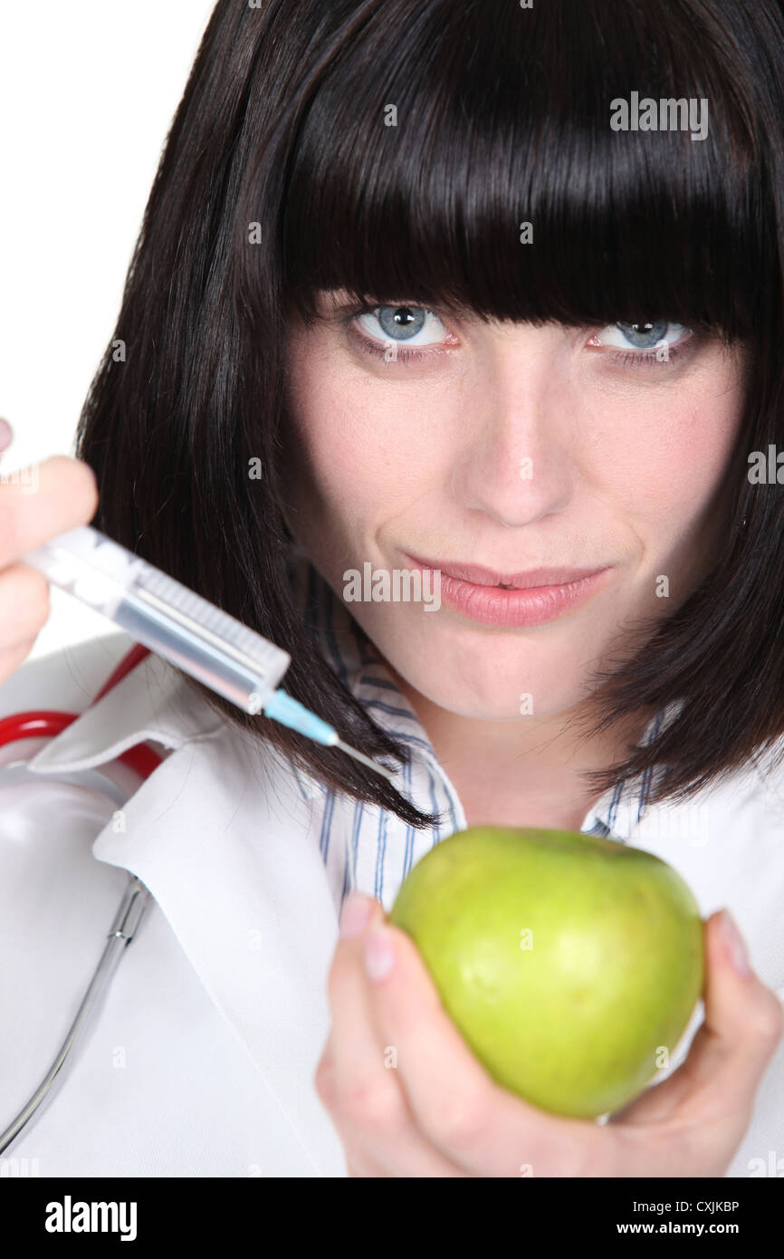 Nurse injecting drug in apple Stock Photo - Alamy