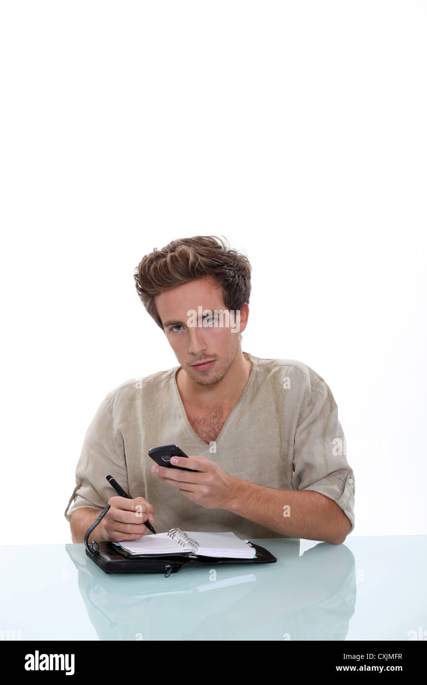 Man copying contact details from diary Stock Photo - Alamy