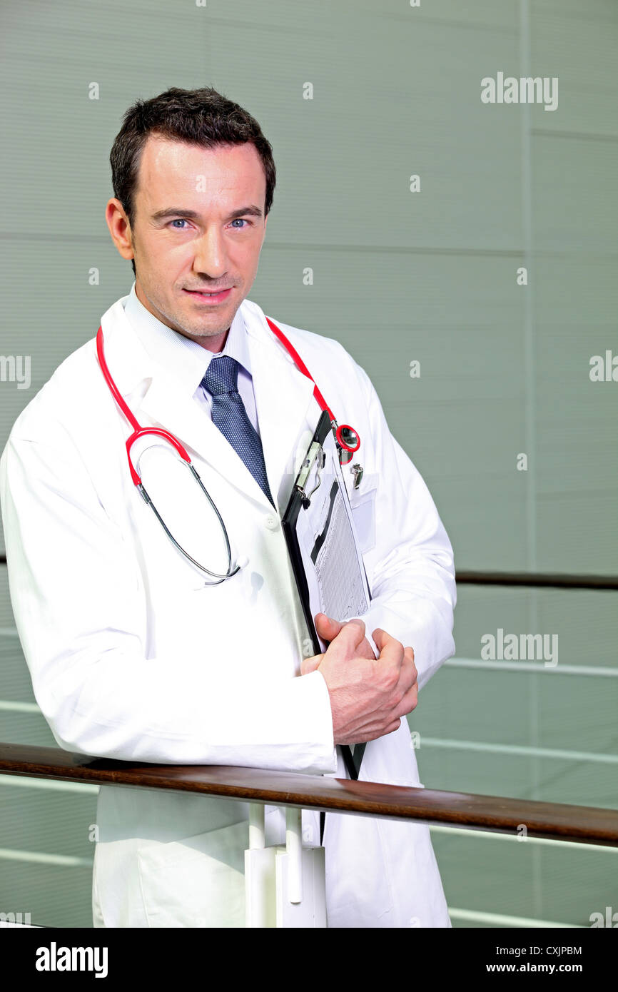 Doctor leaning against railing Stock Photo - Alamy