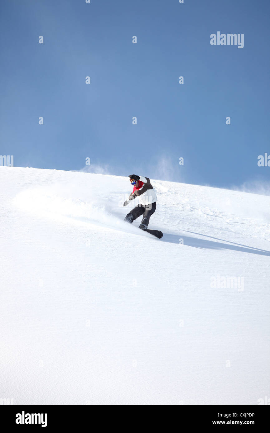 A snowboarder gliding down a slope Stock Photo - Alamy