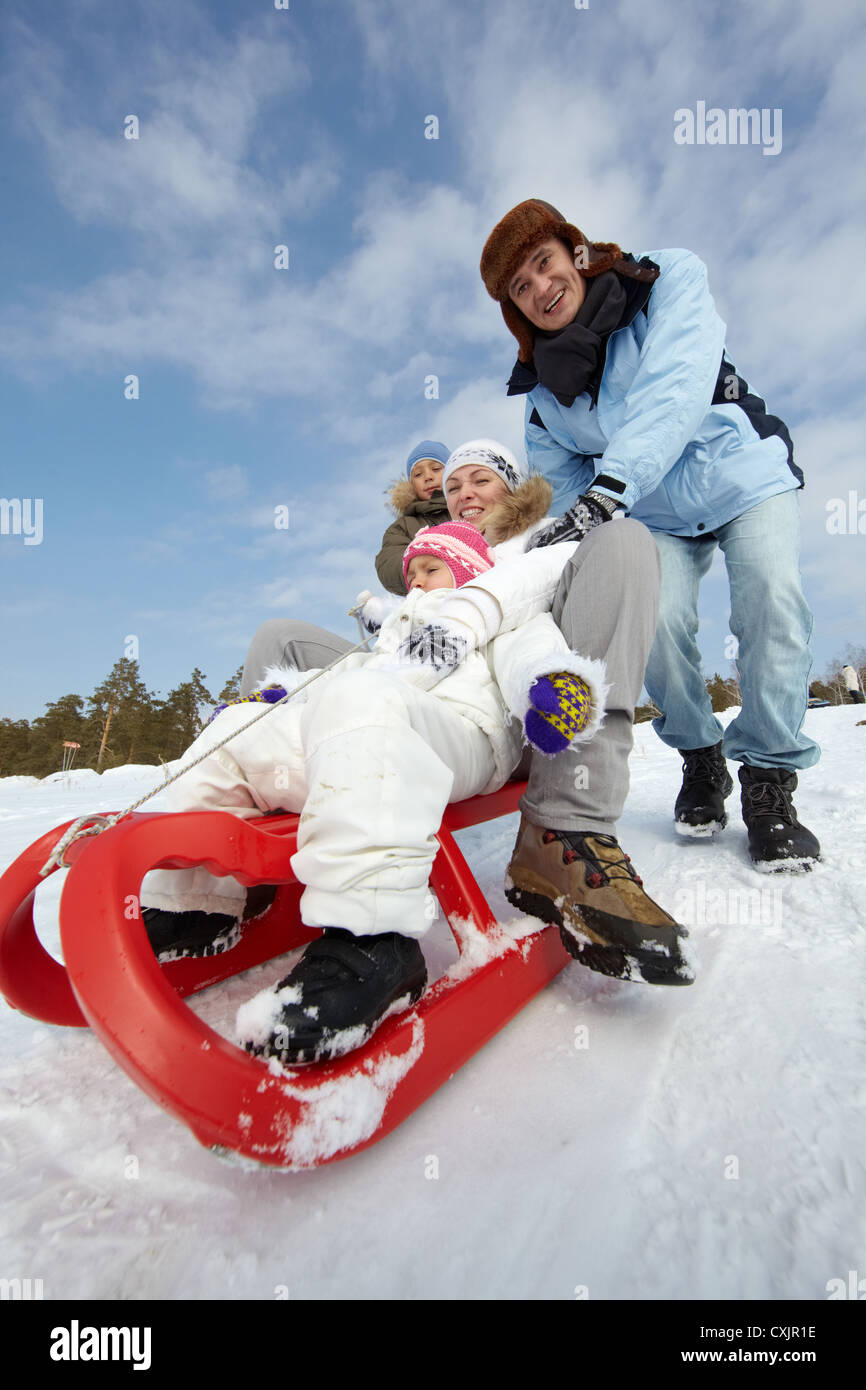 Happy kids and their parents riding on sledge in park Stock Photo - Alamy