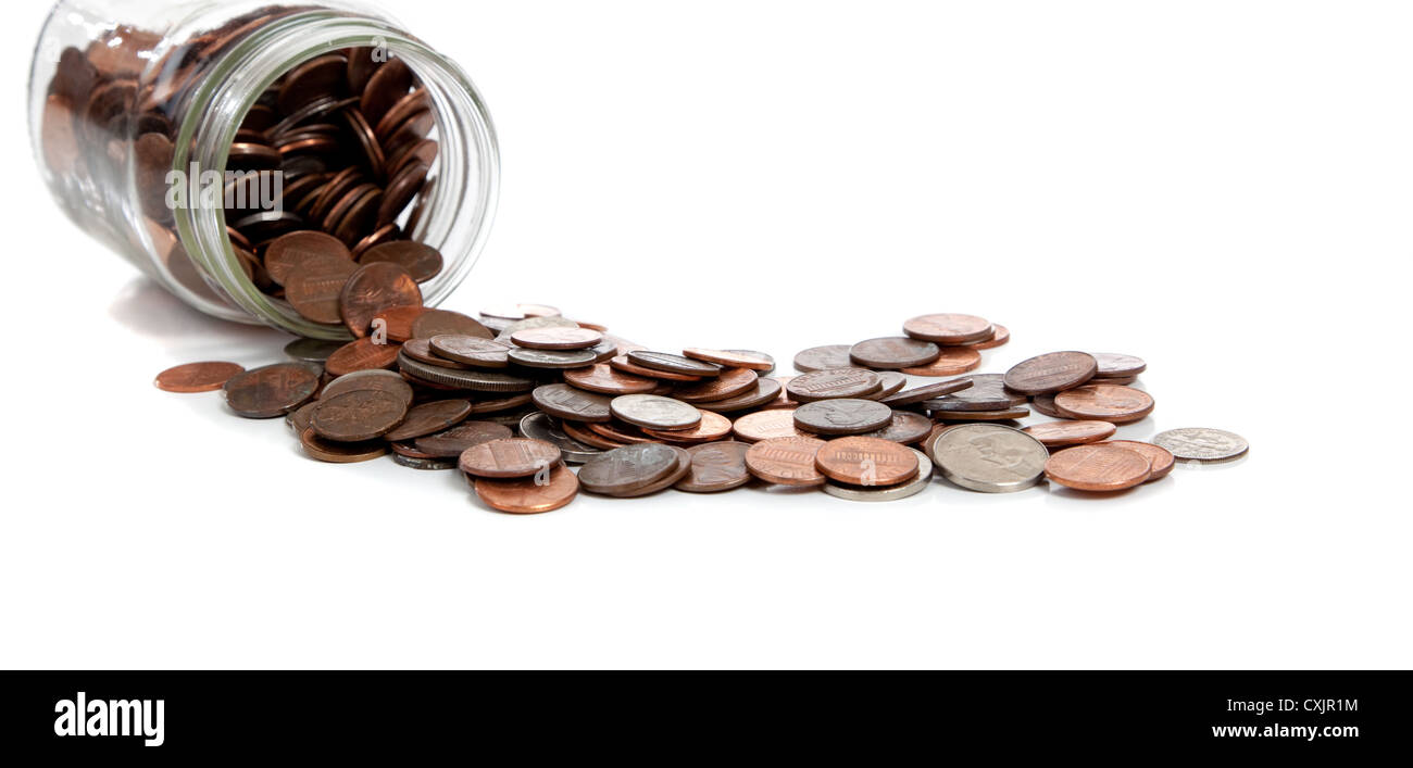 Jar over on the side with change falling out of it on a white ...