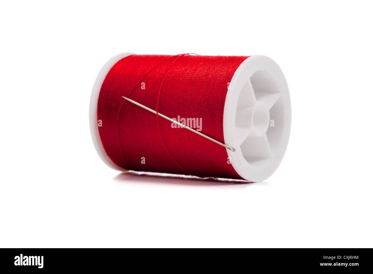 Spool of red thread with a needle on a white background Stock Photo - Alamy