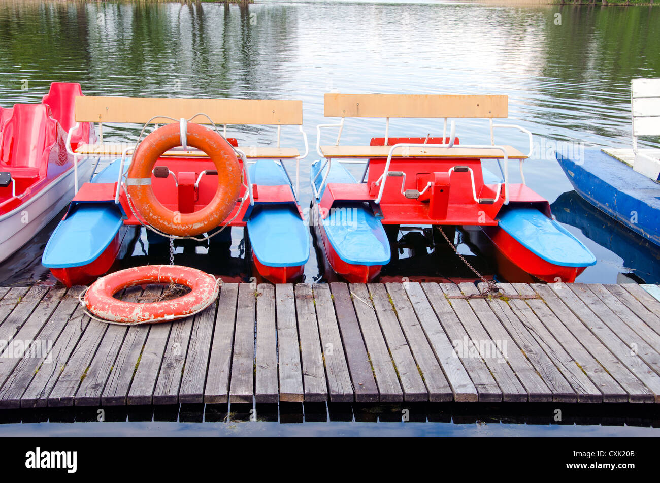 colorful pedalo on resort lake and life buoy Stock Photo - Alamy