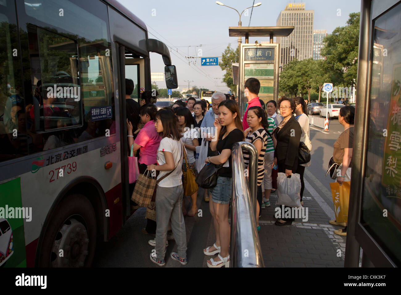 Passengers waiting to embark a bus during rush hour at Fuchengmen in central Beijing, China ...