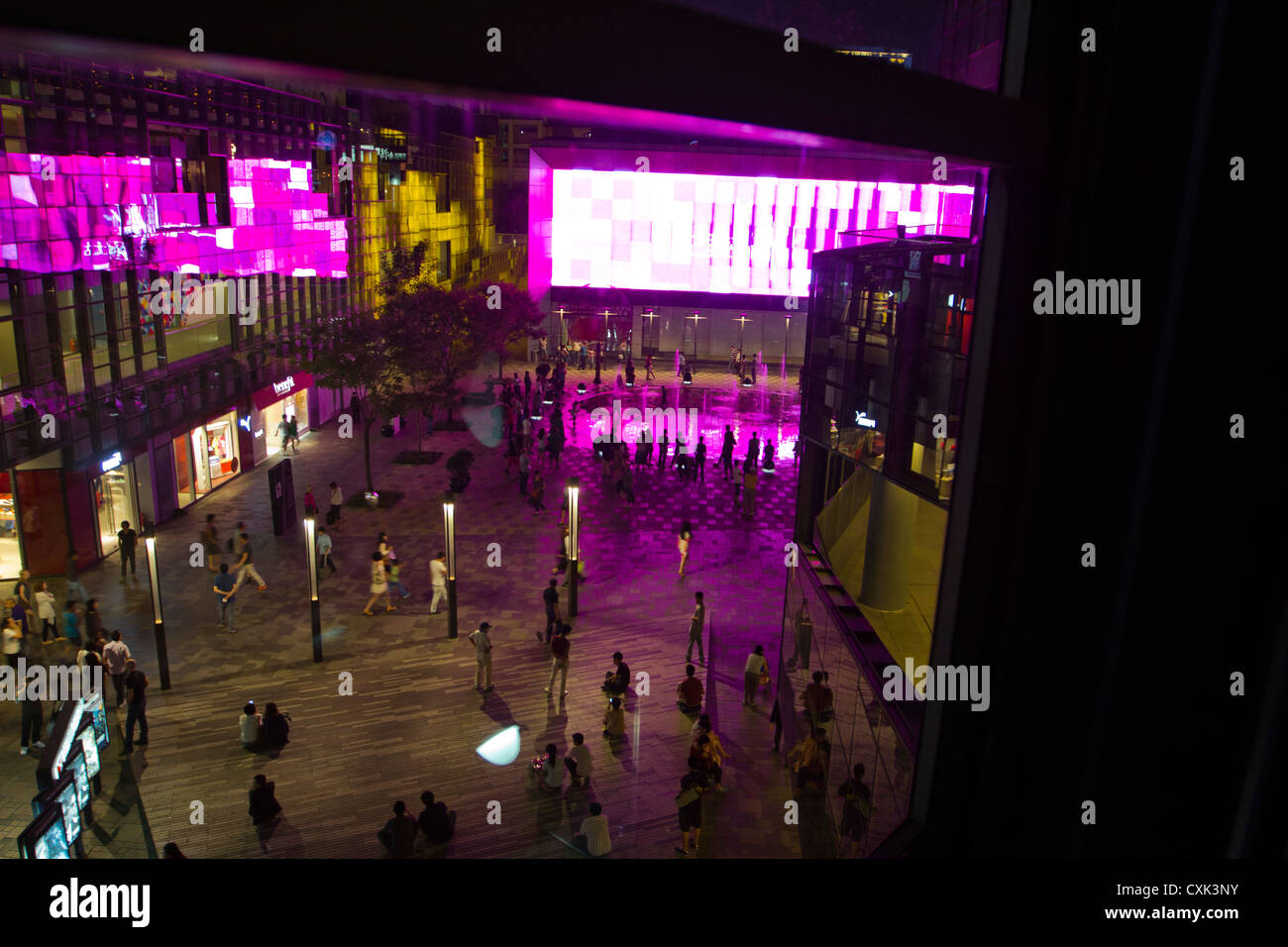 Pedestrians walking through a shopping mall at night in the Sanlitun ...