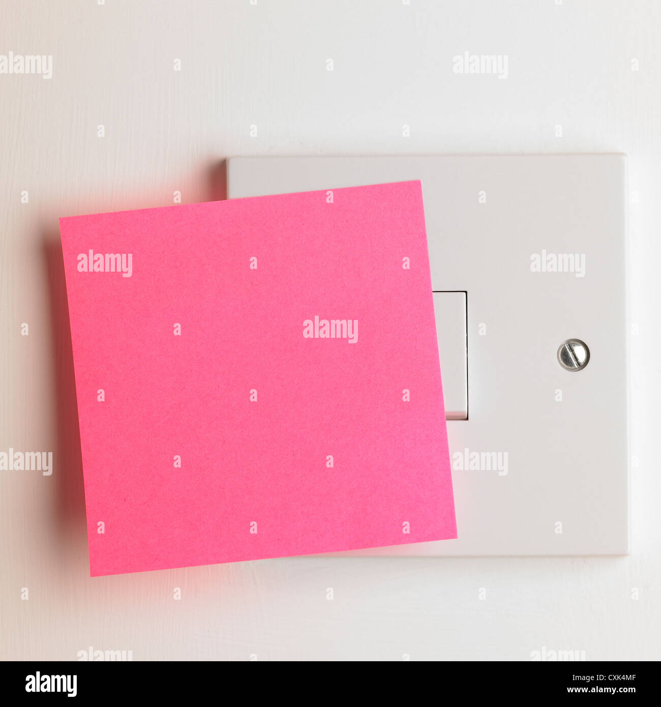 Pink post note on white wall light switch Stock Photo - Alamy