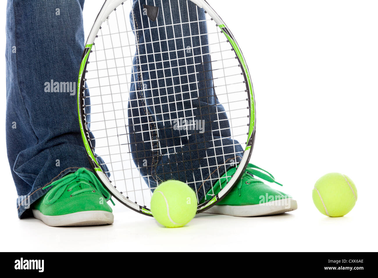 A teenager stand with a tennis racket and 2 tennis balls against a ...