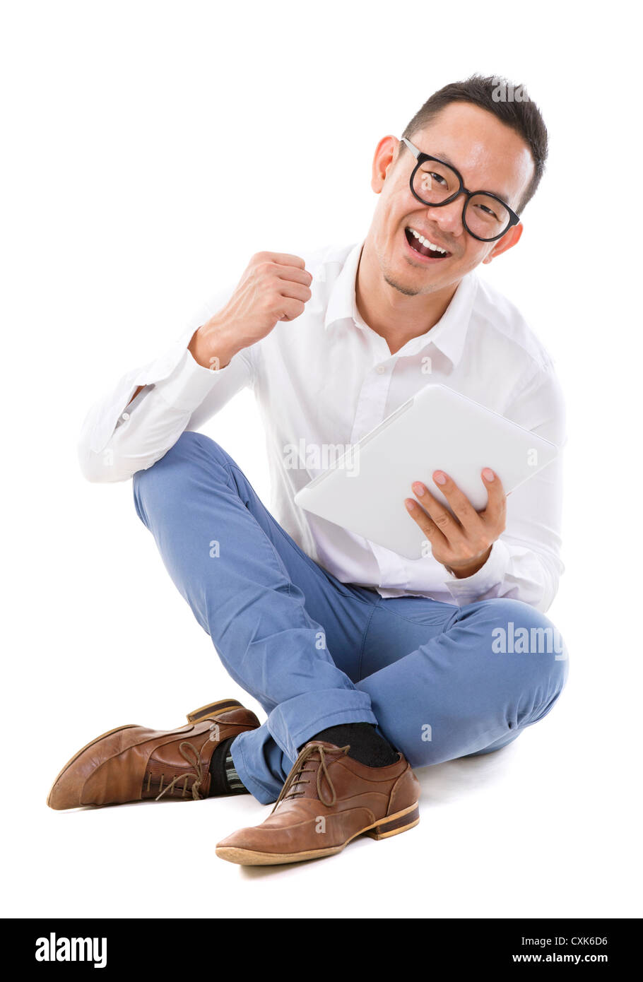Fullbody happy Asian man sitting on floor using tablet computer Stock ...