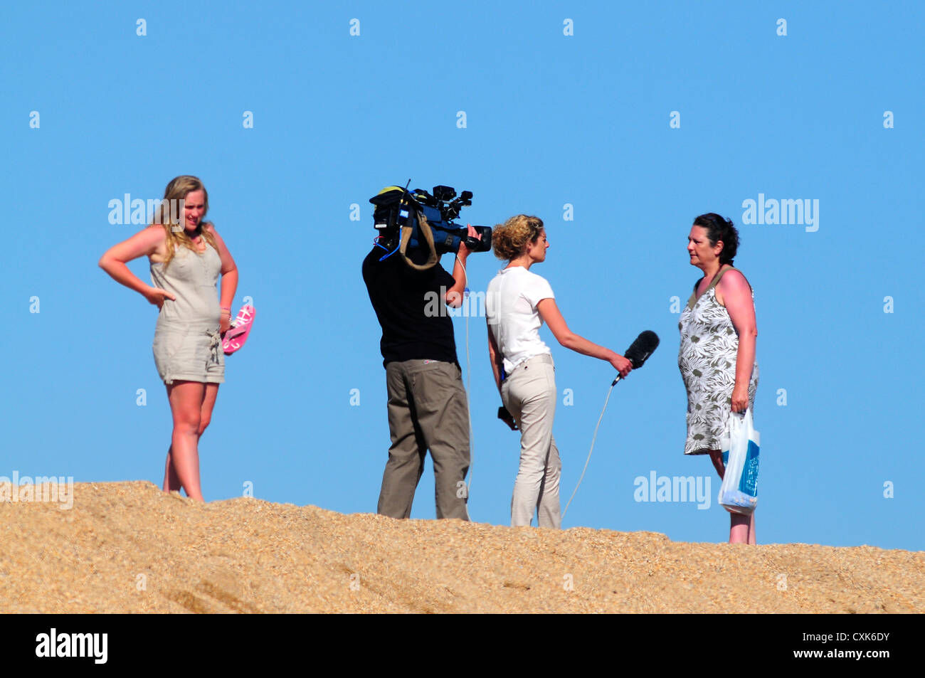A woman being interviewed for television on a beach UK Stock Photo - Alamy