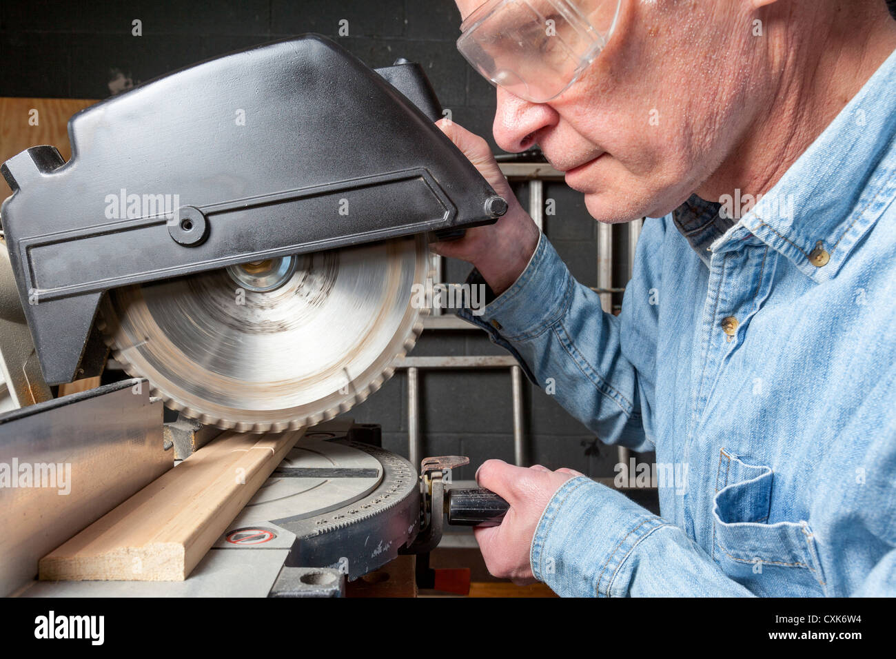 A middle aged man cuts wood with an electric saw Stock Photo - Alamy