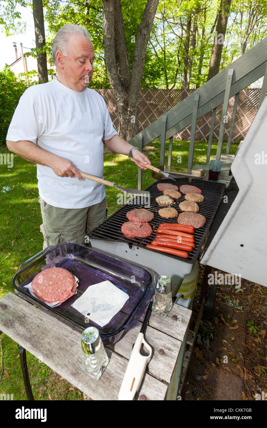 A man cooks food on his grill in his backyard Stock Photo - Alamy