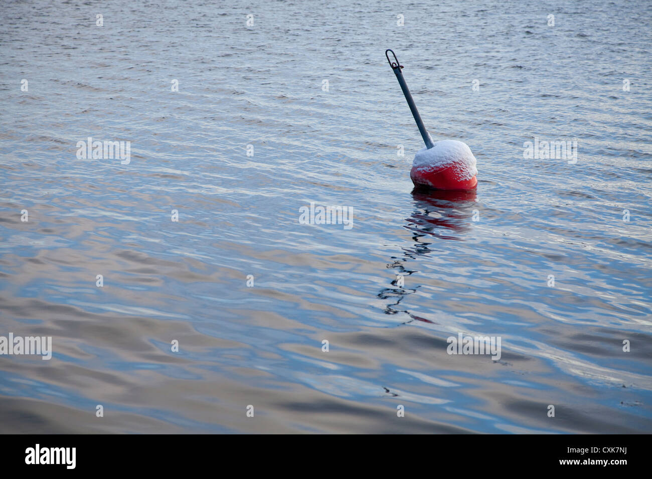 orange boat buoy with snow in the water Stock Photo - Alamy