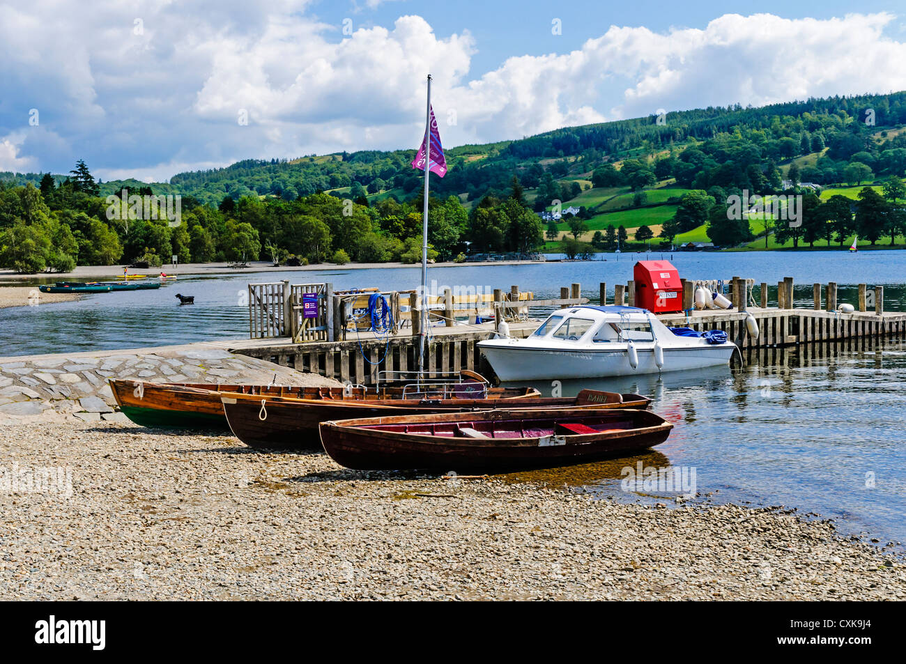 Empty rowing boats drawn up on the shingle beach and a motor boat ...
