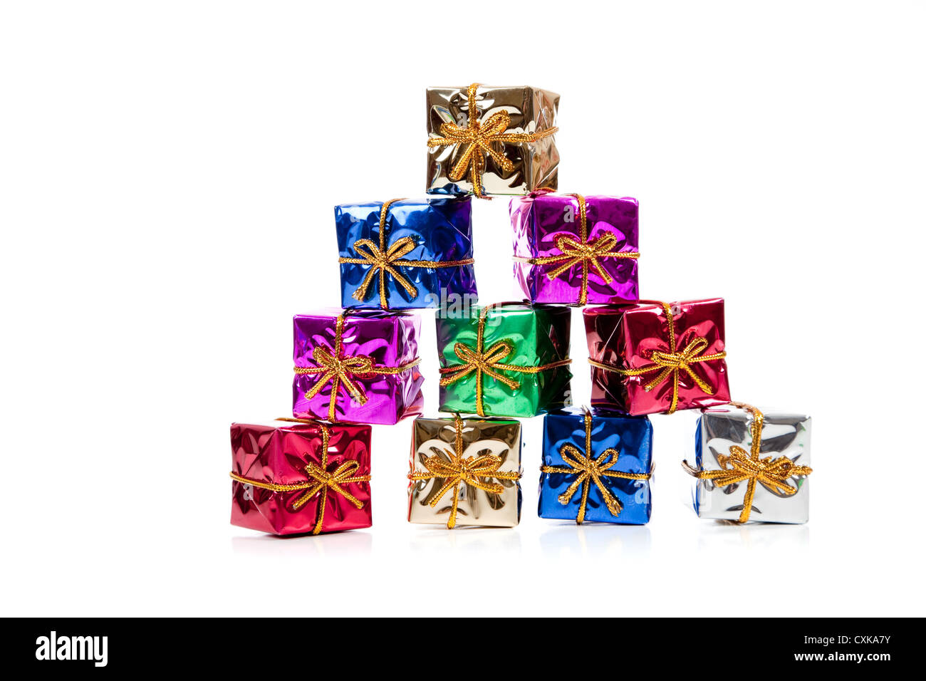 Stack of tiny brightly colored wrapped Christmas presents on a white ...