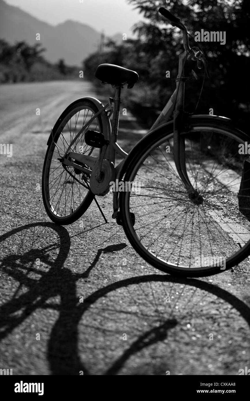Bicycle and shadow on country road Stock Photo - Alamy