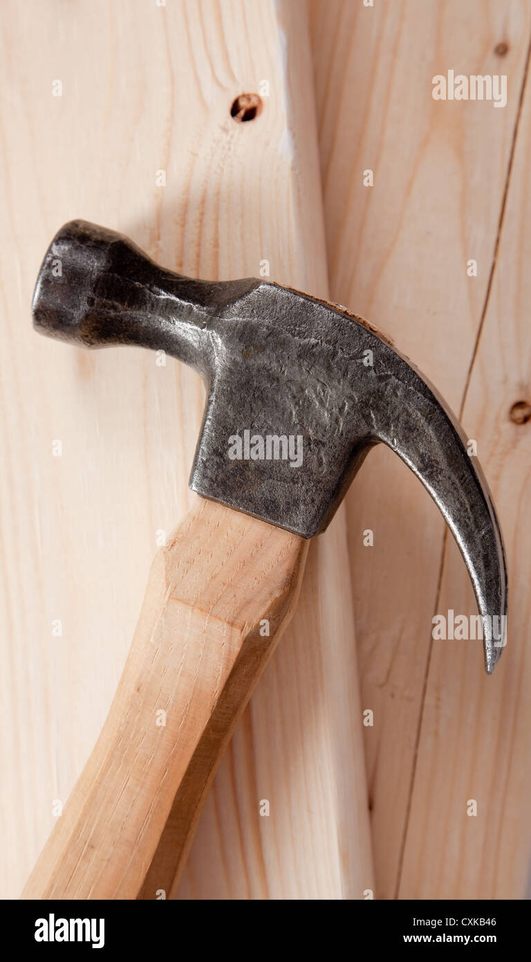 A hammer laying on a plywood board background Stock Photo - Alamy