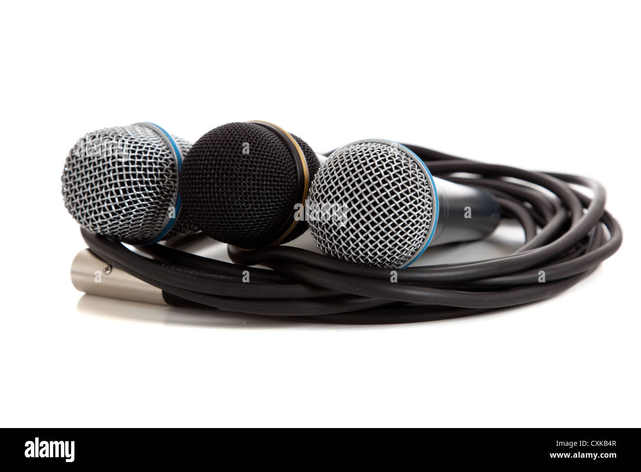 Trio of microphones with cords on a white background Stock Photo - Alamy