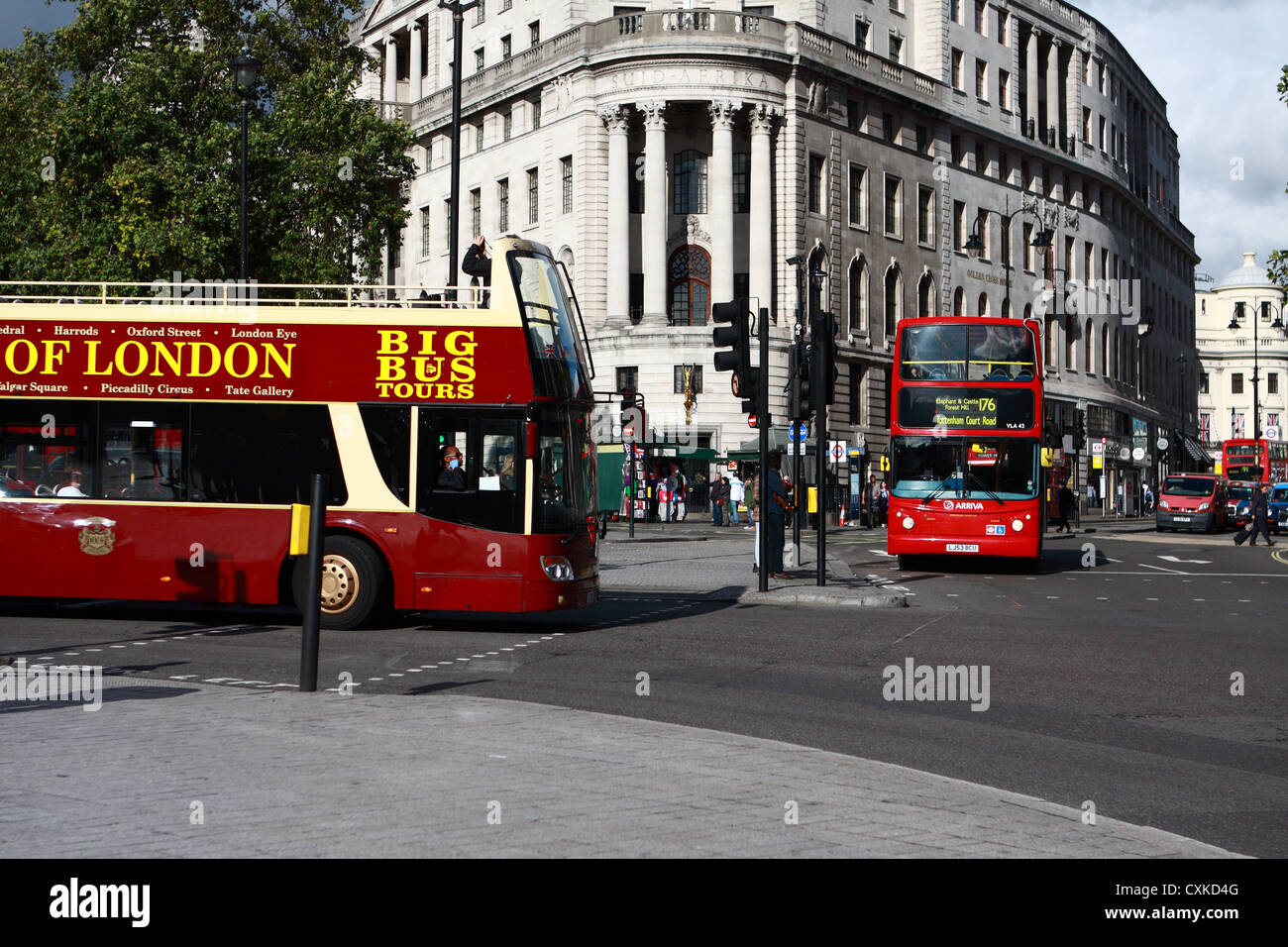 Red London double decker bus and a tour bus traveling in London Stock ...