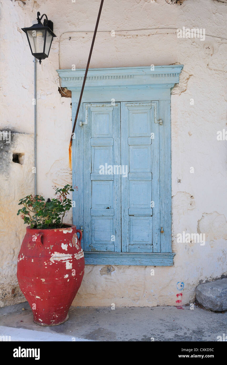 Study of an old greek window with shutters and terracotta planter in ...