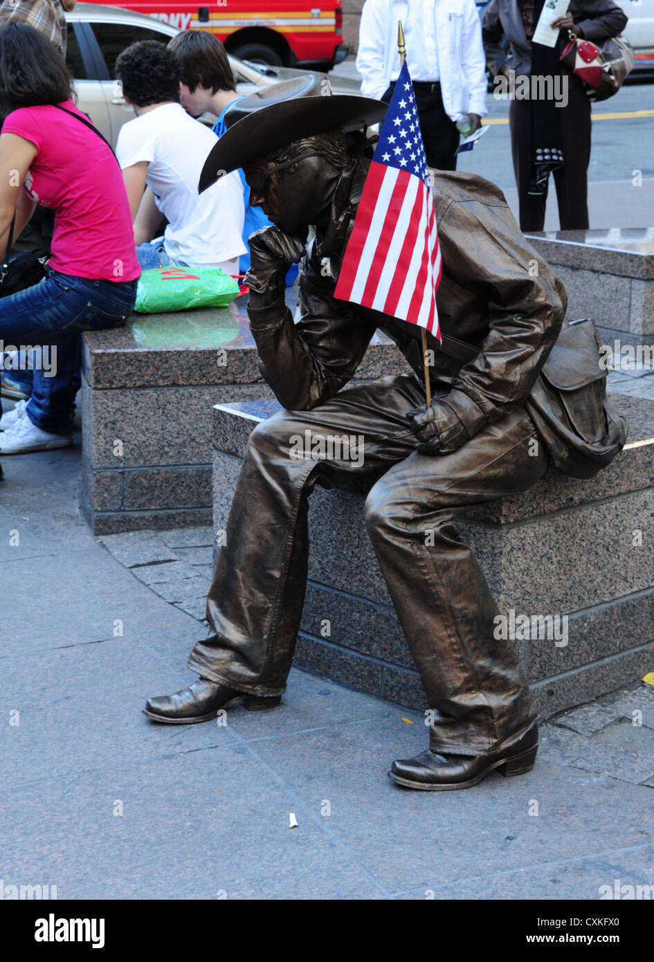 Masked cowboy mime artist, holding American Flag, sitting granite seat ...