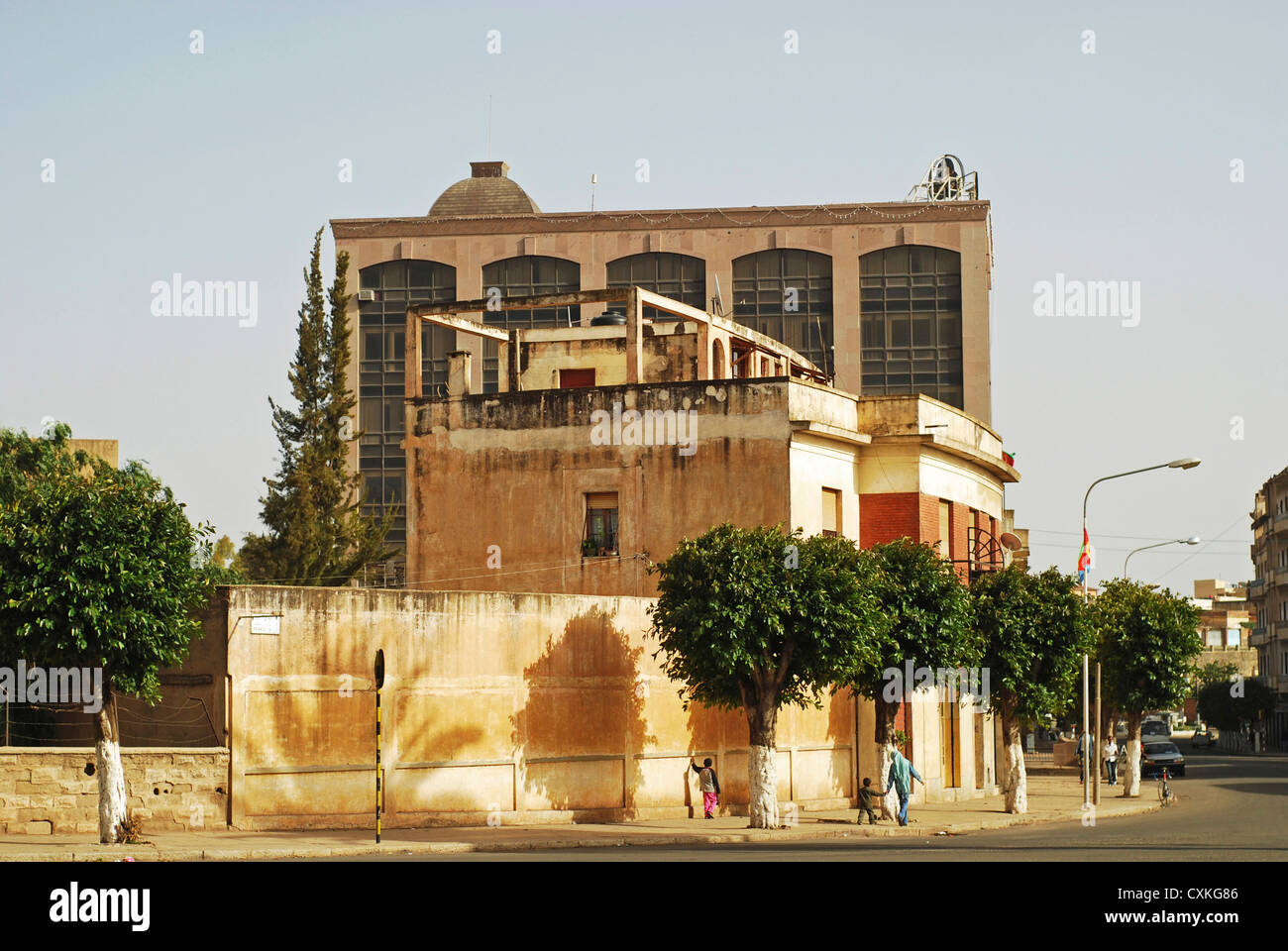Eritrea, Asmara, people walking on pathway, bus on street with buildings in the background Stock ...