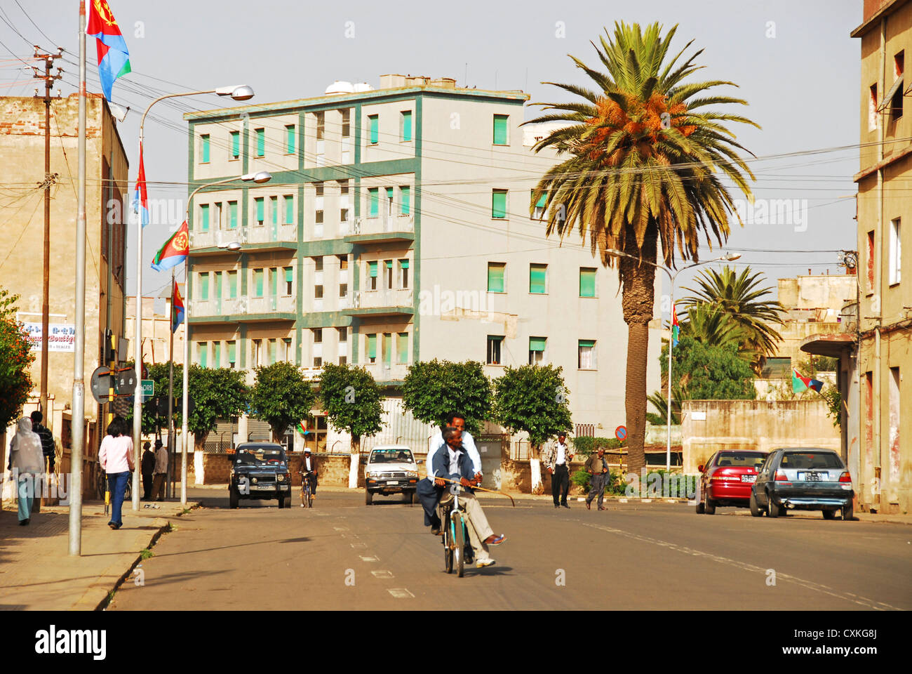 Eritrea, Asmara, men on a bicycle on the street with buildings in the ...