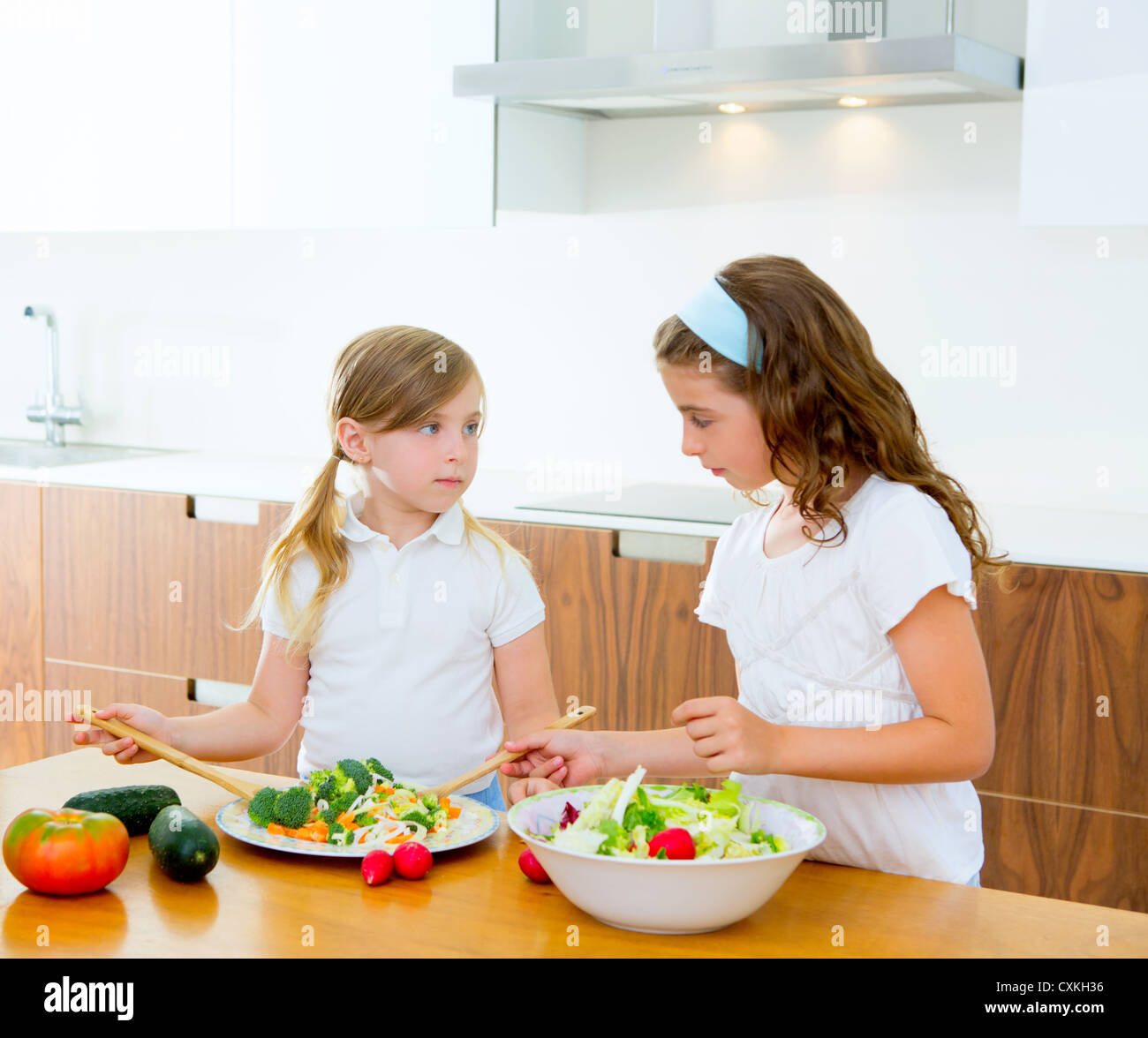 Beautiful chef sisters at home kitchen preparing salad Stock Photo - Alamy