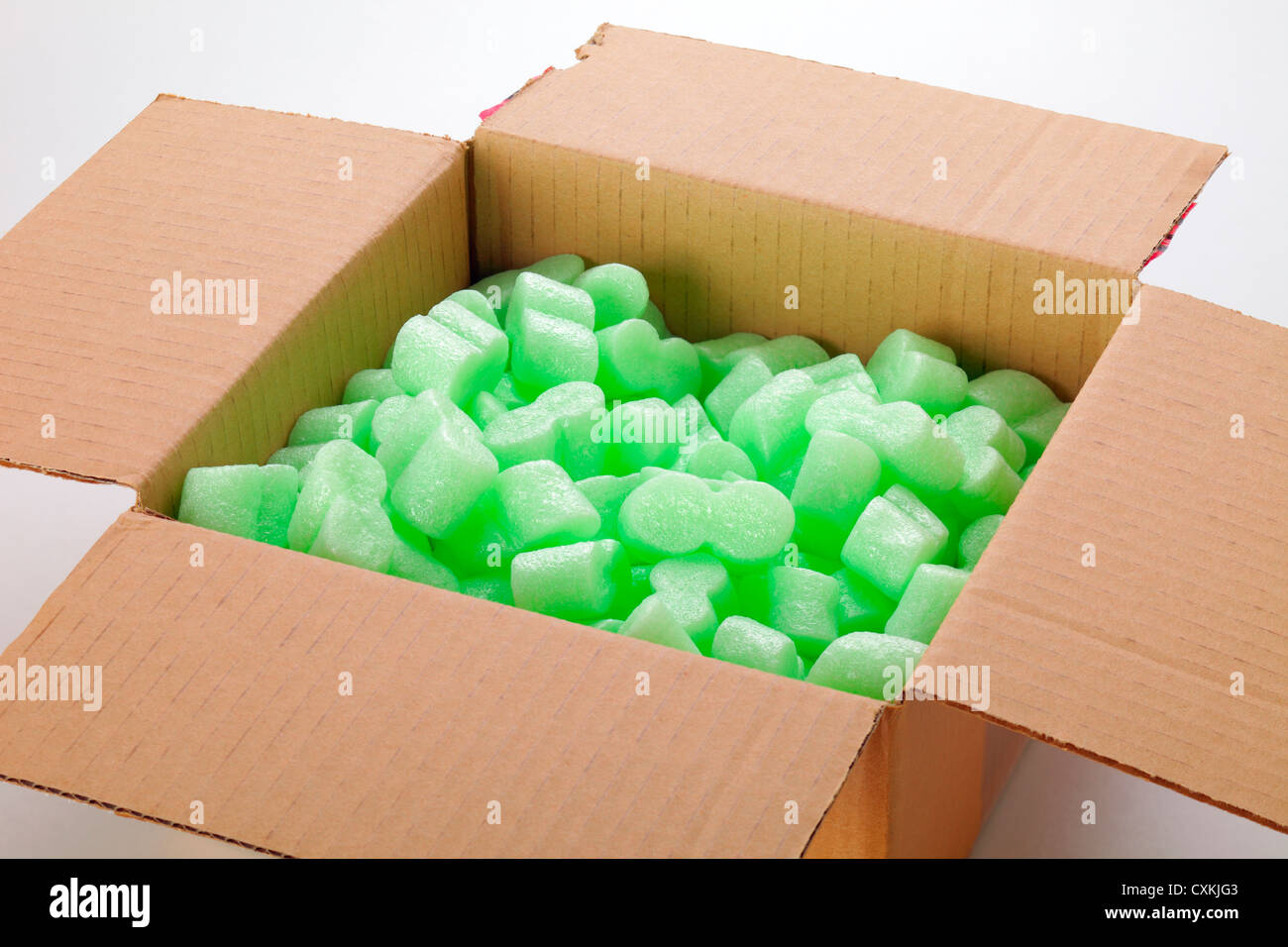 A cardboard box with green packing styrofoam peanuts Stock Photo - Alamy