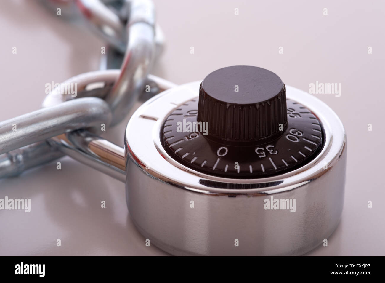 A combination lock and a silver chain on a white background with copy ...