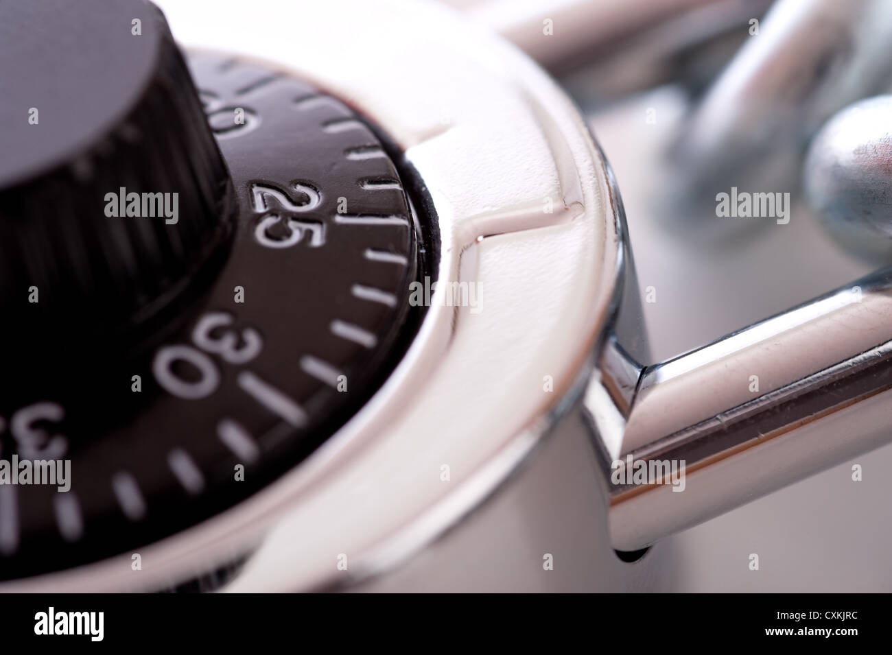 A combination lock and a silver chain on a white background with copy ...