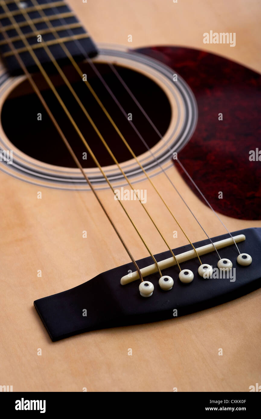 A 6-string acoustic guitar background with focus on the bridge, with ...