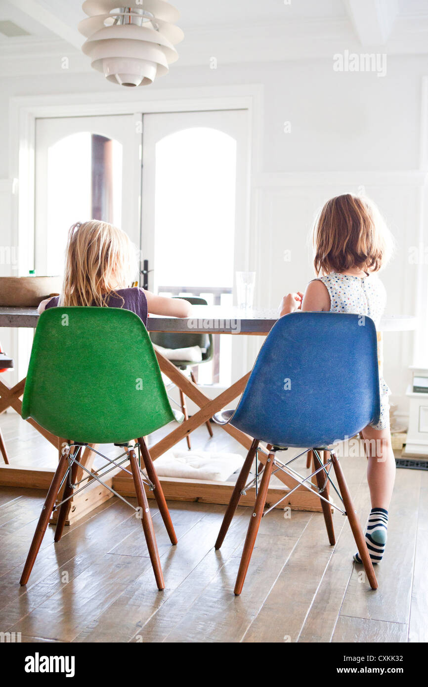 Young girls sitting at modern table Stock Photo - Alamy