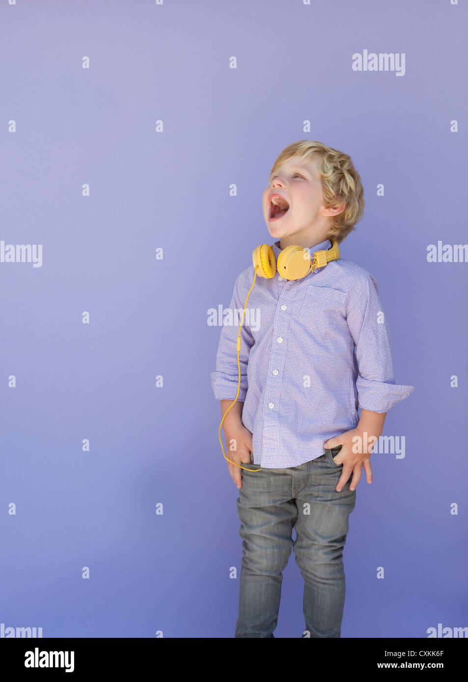 Young boy with yellow headphones yelling Stock Photo - Alamy