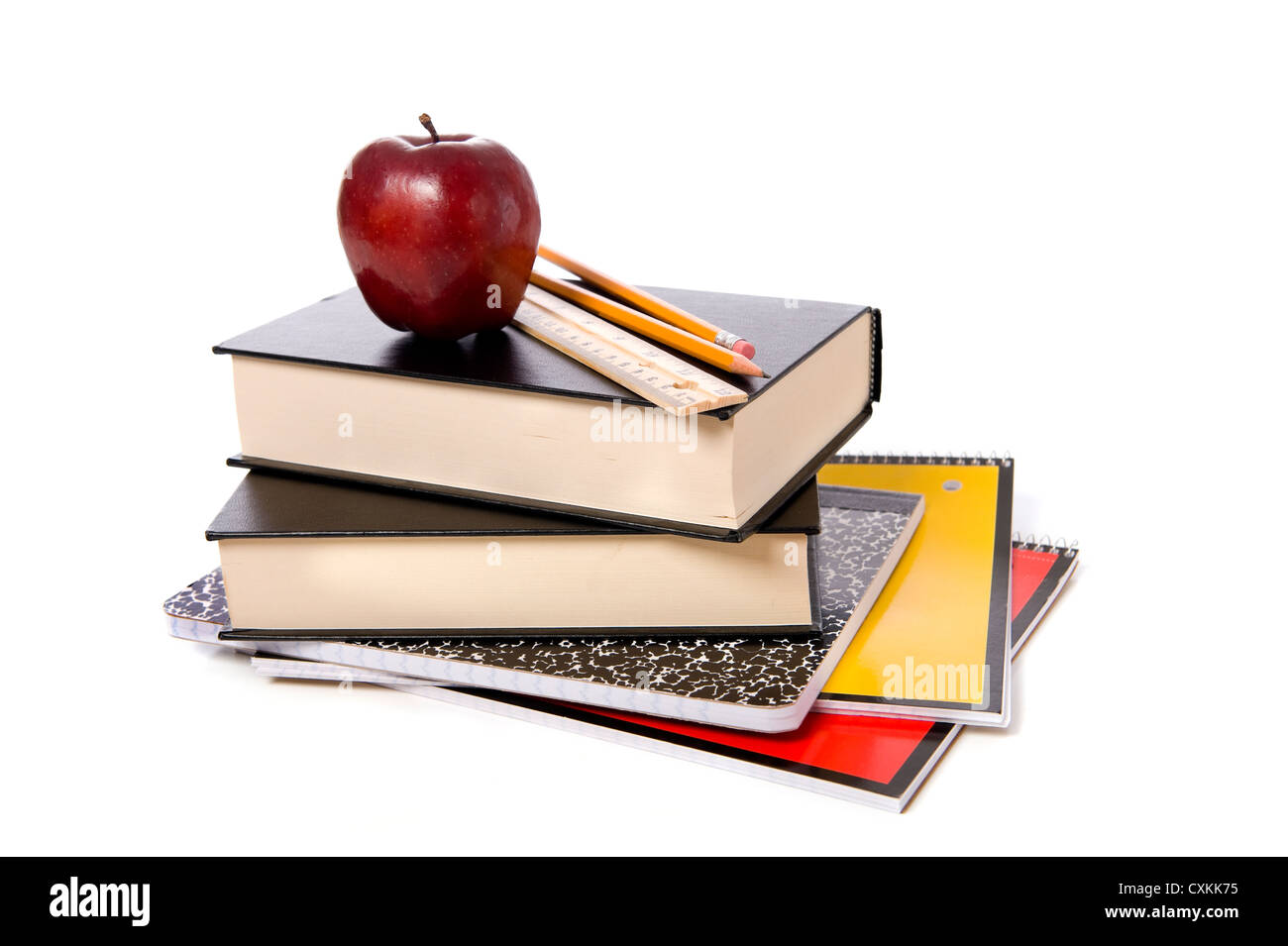 A stack of school books and spiral notebooks with a pencil and a ruler ...