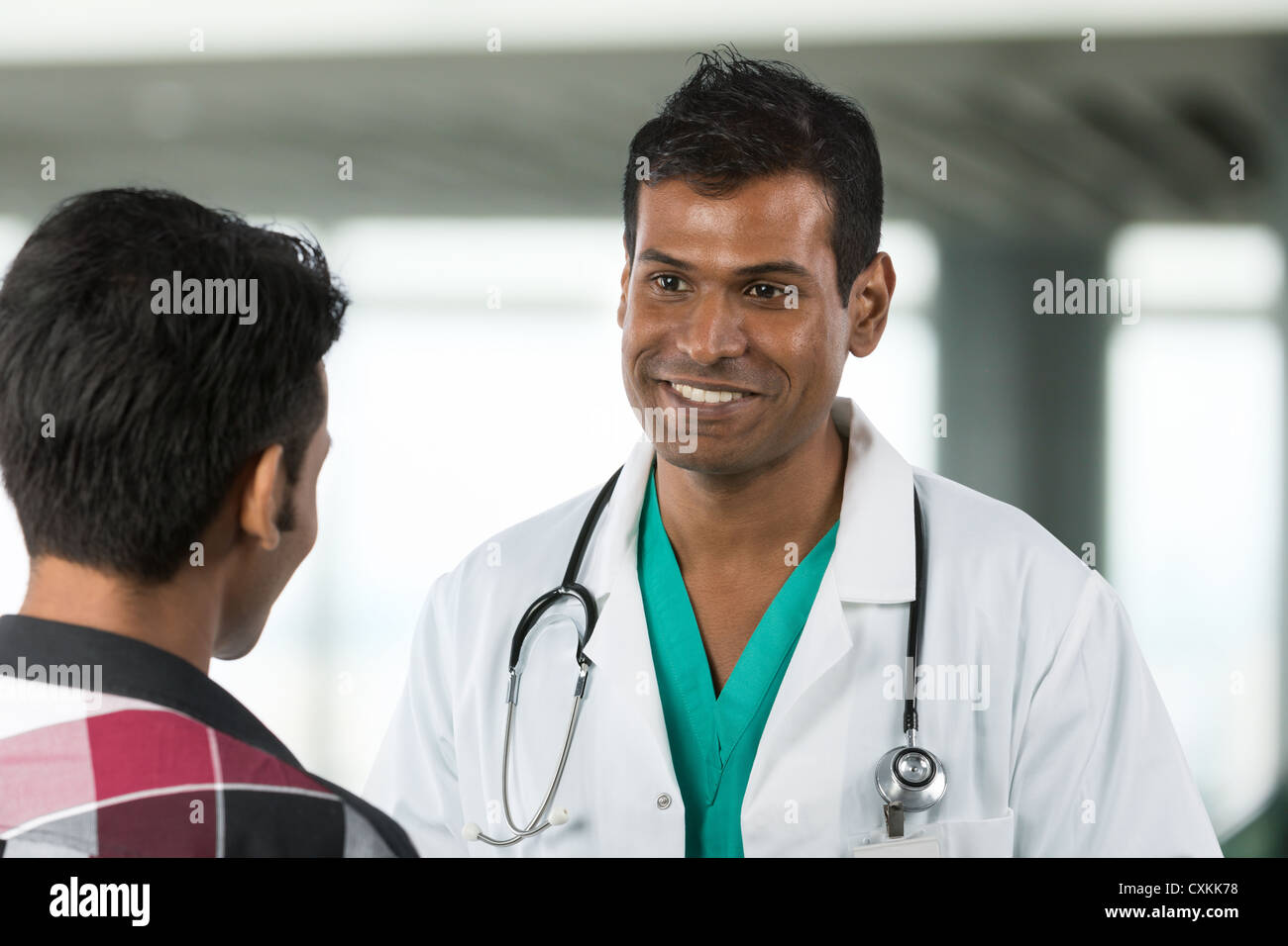 Male Indian Doctor talking to a patient in a hospital Stock Photo - Alamy