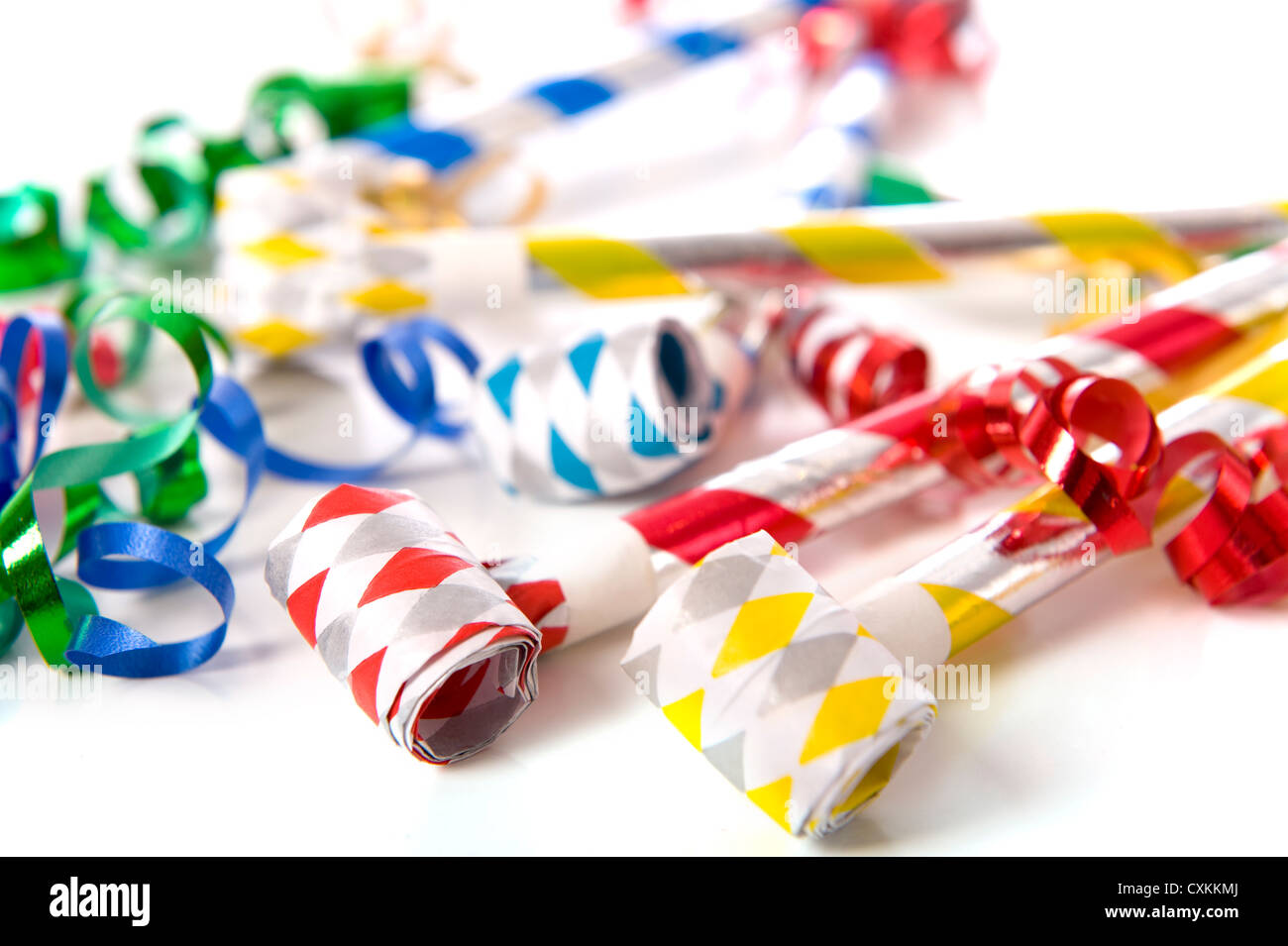 A group of party items, noisemakers and ribbons, on a white background ...