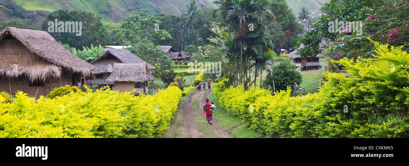 Children walking along a dirt road in a traditional village scene, Erap ...