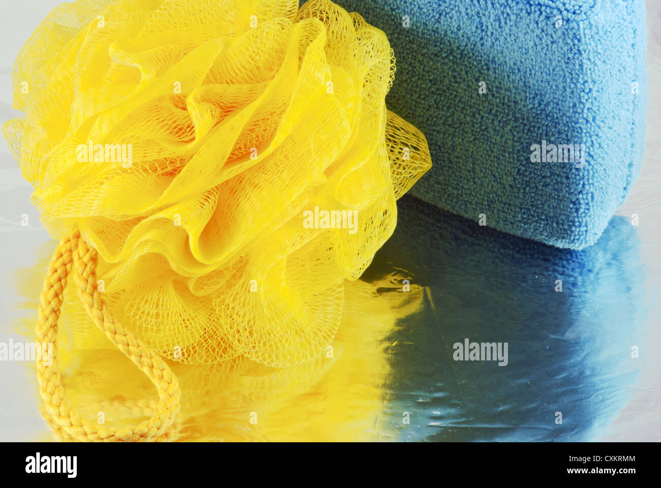 Yellow and blue bath sponge with reflection Stock Photo - Alamy