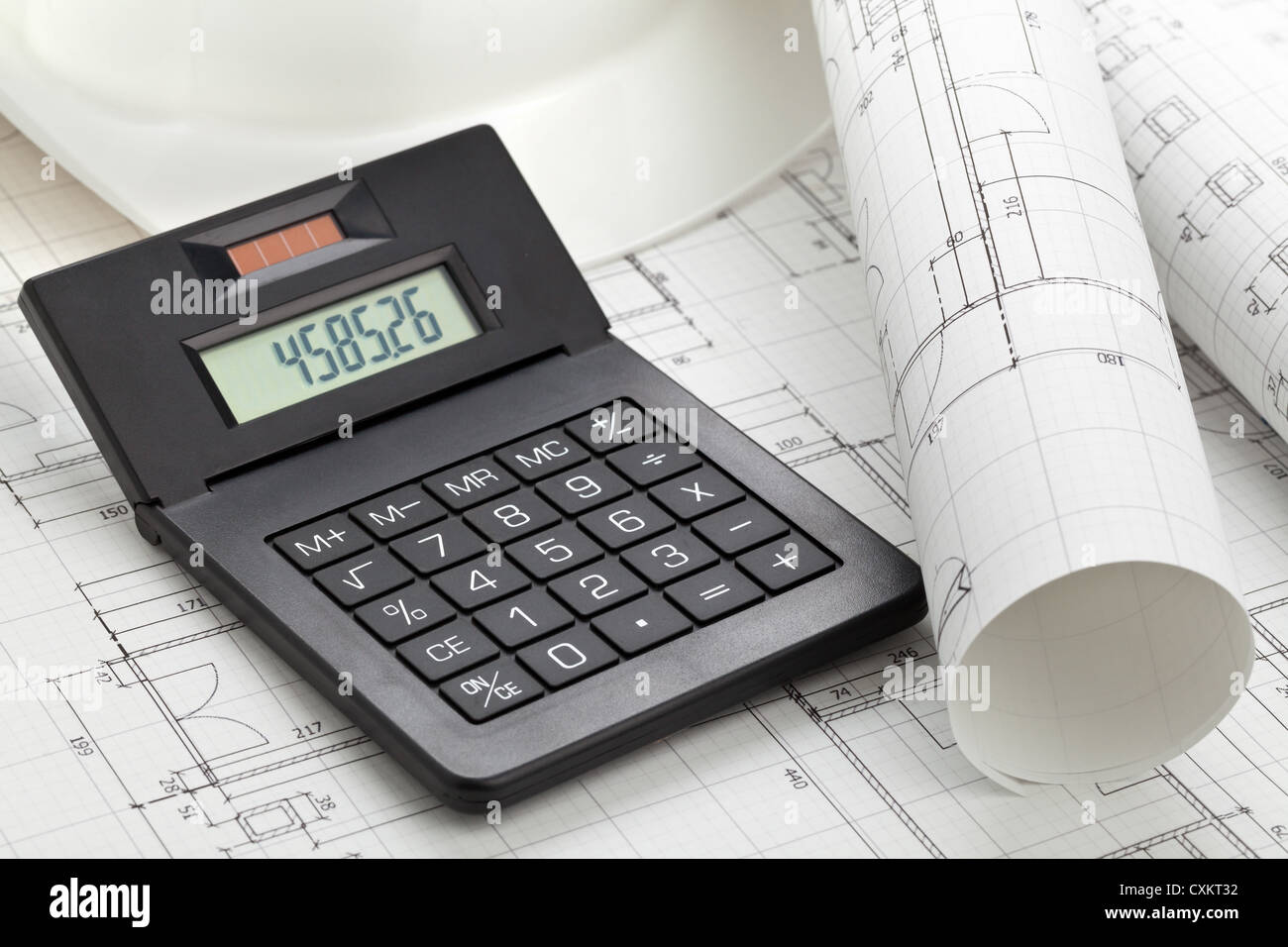 Calculator on house construction blueprints with hardhat Stock Photo ...