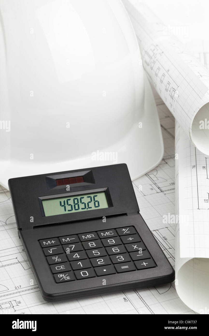 Calculator on house construction blueprints with hardhat Stock Photo ...