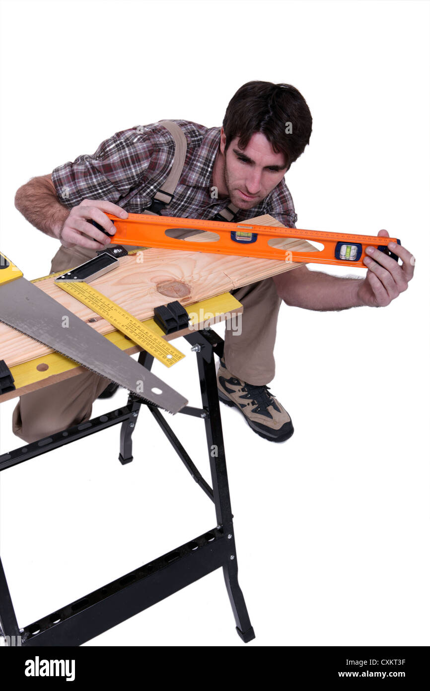Carpenter leveling plank Stock Photo - Alamy