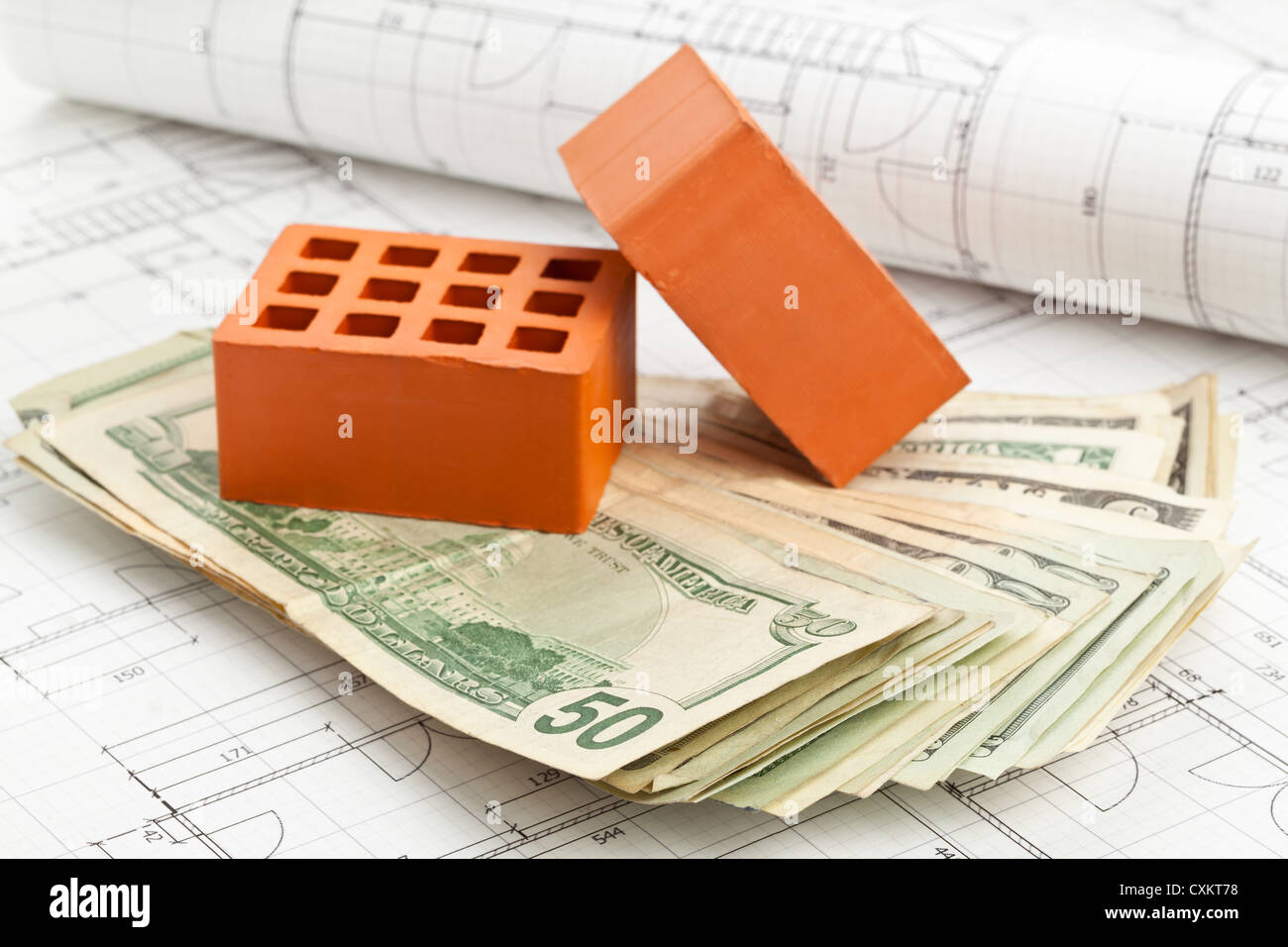 Brick stones with dollar banknotes on home construction blueprints ...