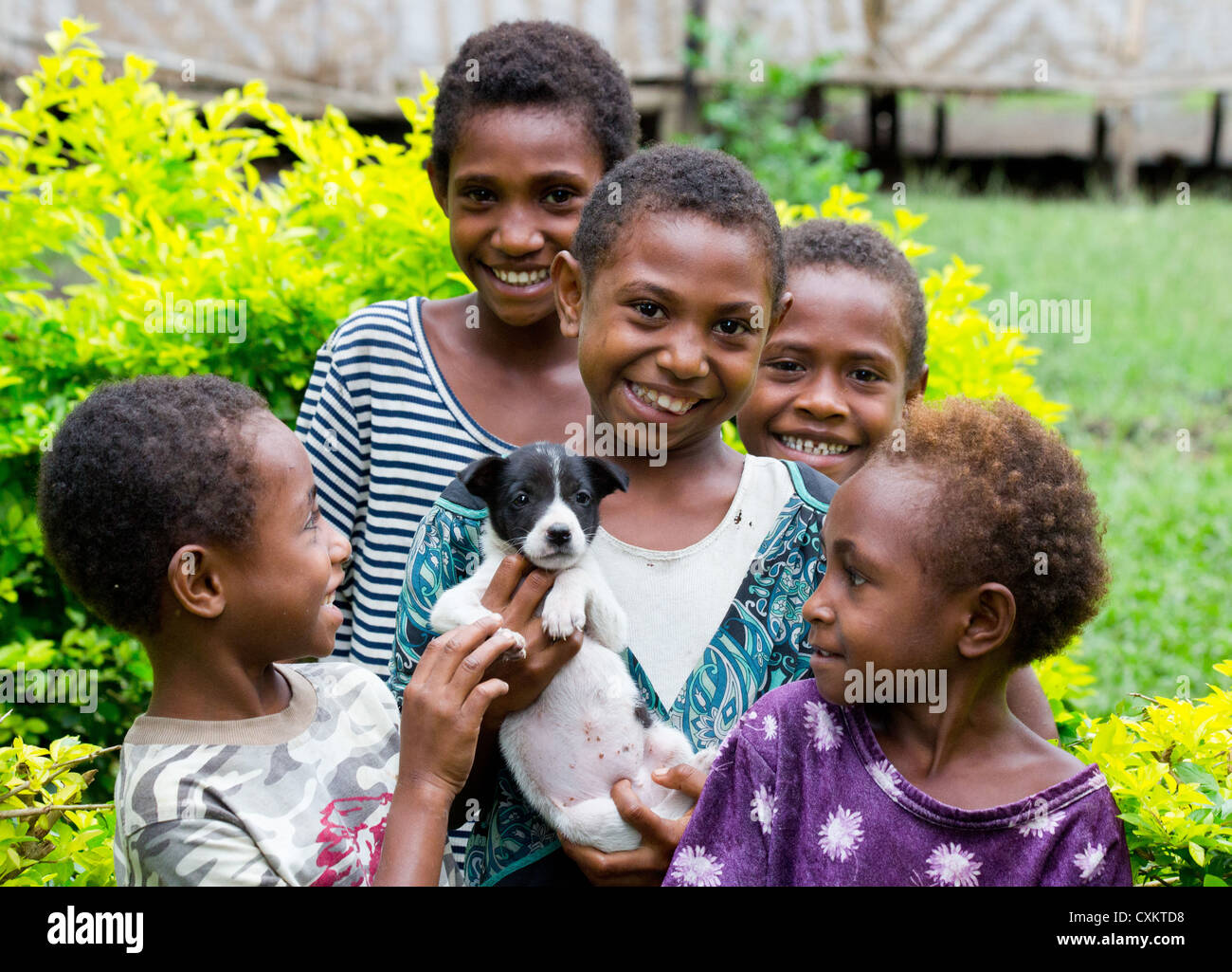 Group of children with a small puppy in a village in the Erap Valley ...