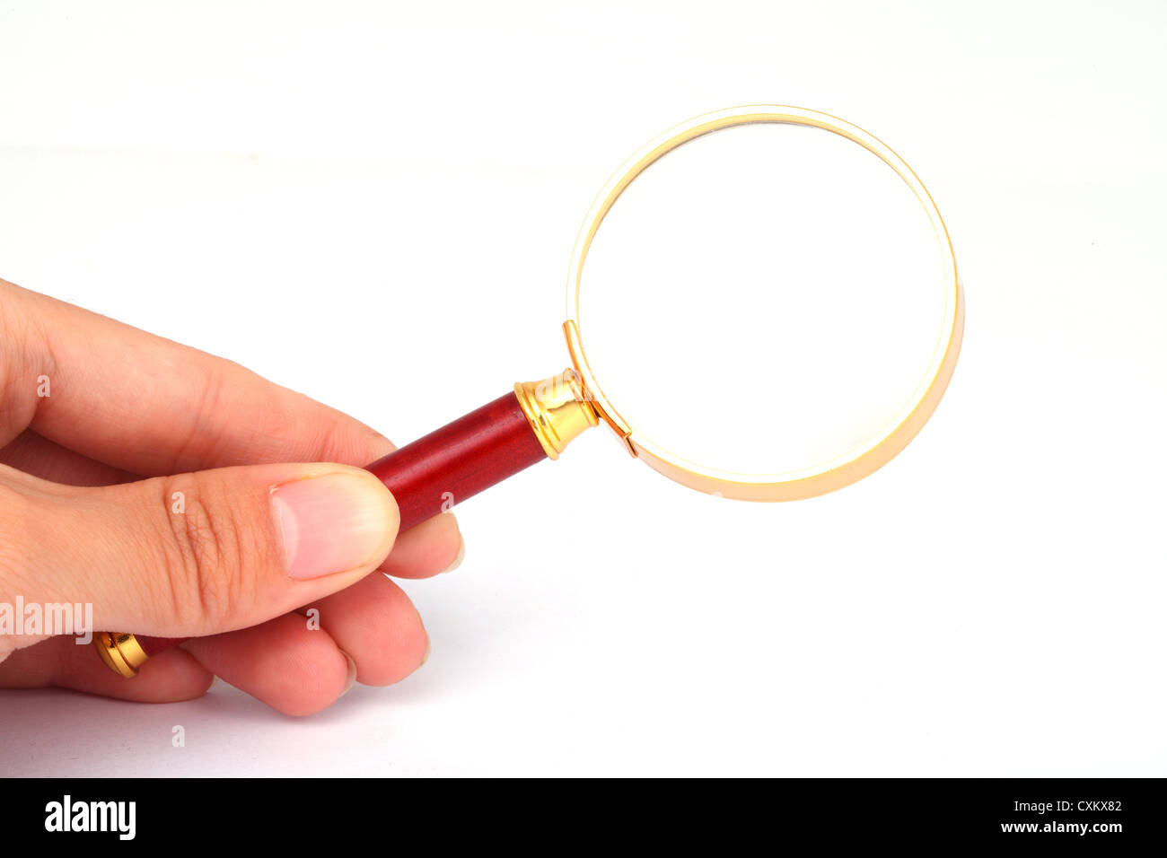 A hand holding a magnifying glass Stock Photo - Alamy