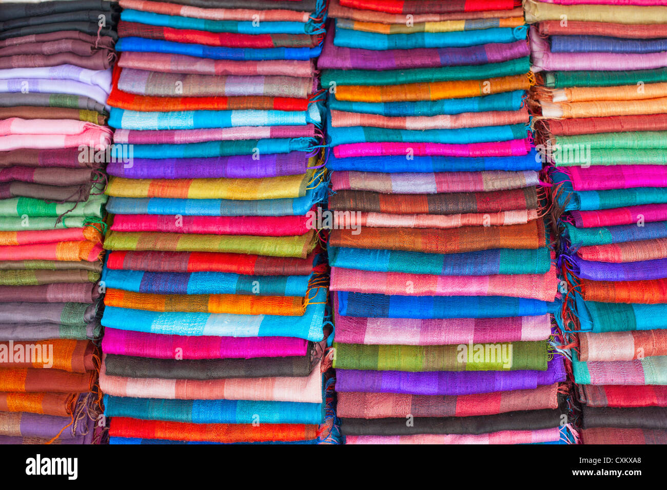 Colourful silk textiles on display at a market stall in Luang Prabang ...