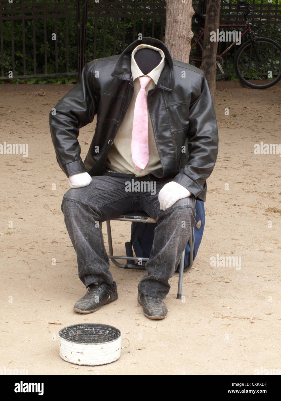 beggar dressed without head in a black leather jacket sitting on a ...