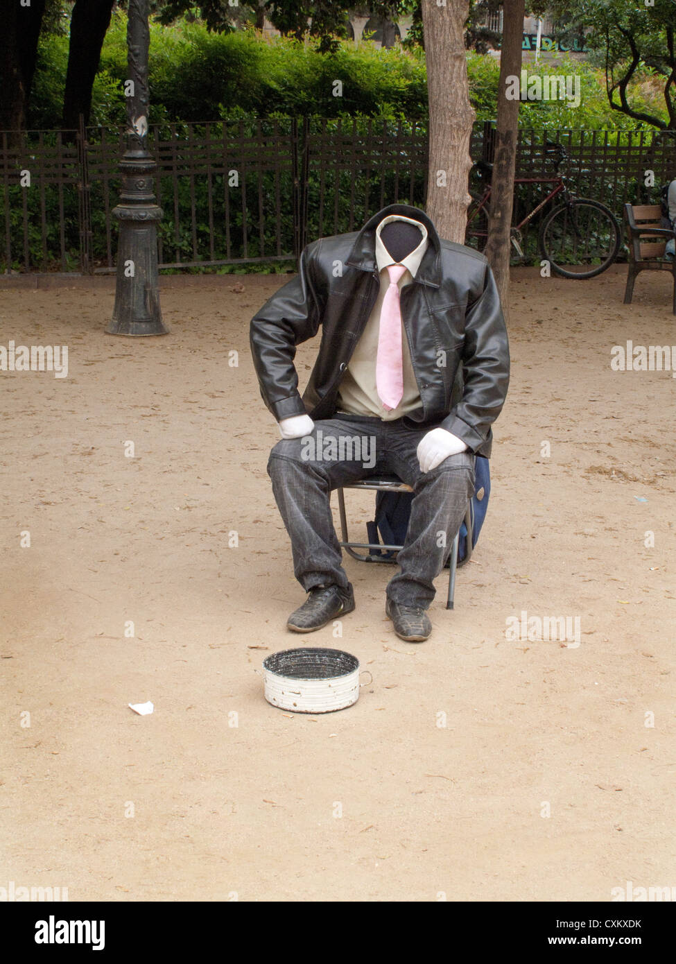 beggar dressed without head in a black leather jacket sitting on a ...